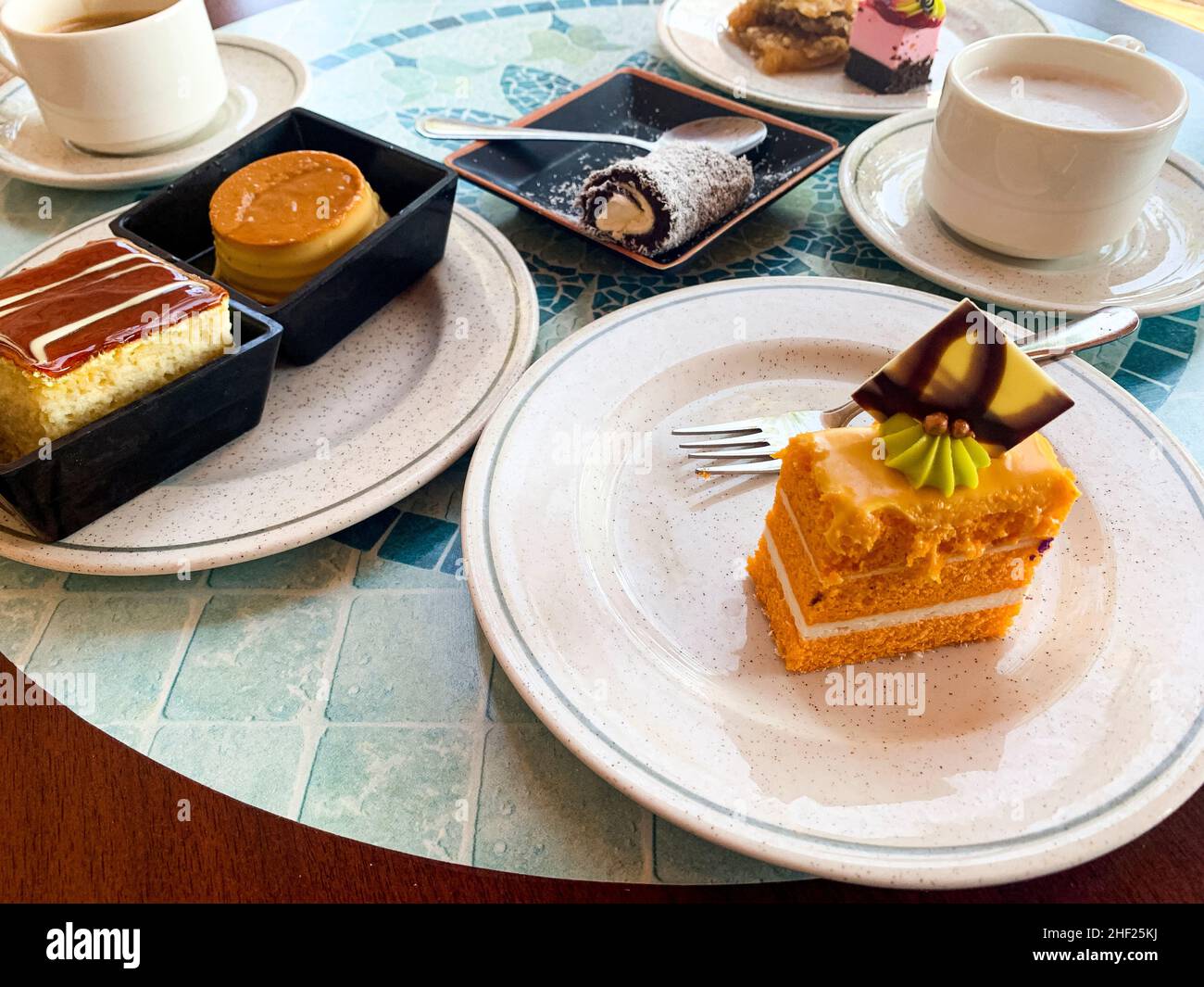 Various colored cakes on plates. Sweet desserts. Photo Stock Photo - Alamy