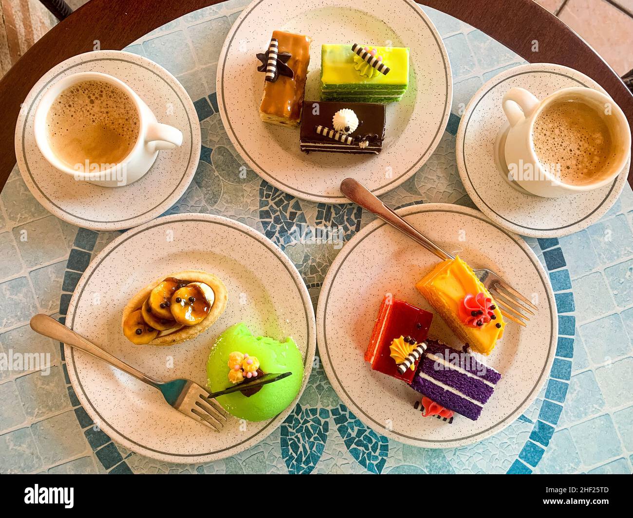 Various colored cakes on plates. Sweet desserts. Photo Stock Photo - Alamy