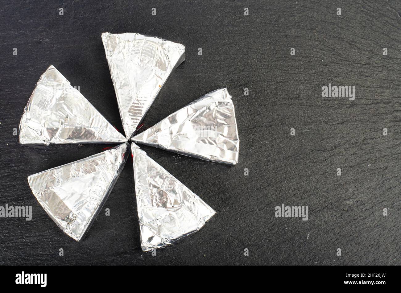 Cheese triangles in foil. Studio Photo Stock Photo - Alamy