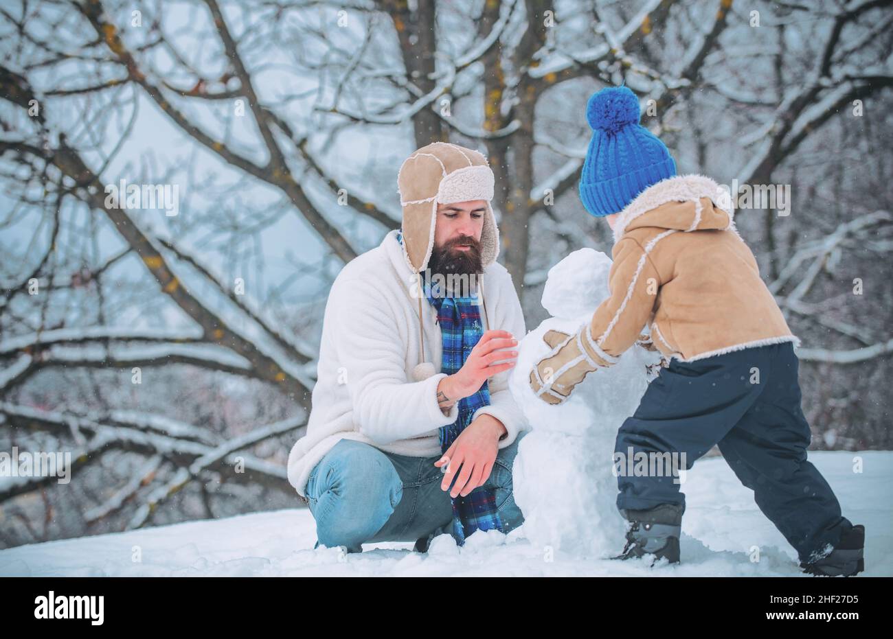 Happy family plaing with a snowman. Fathers day. Father and his son ...
