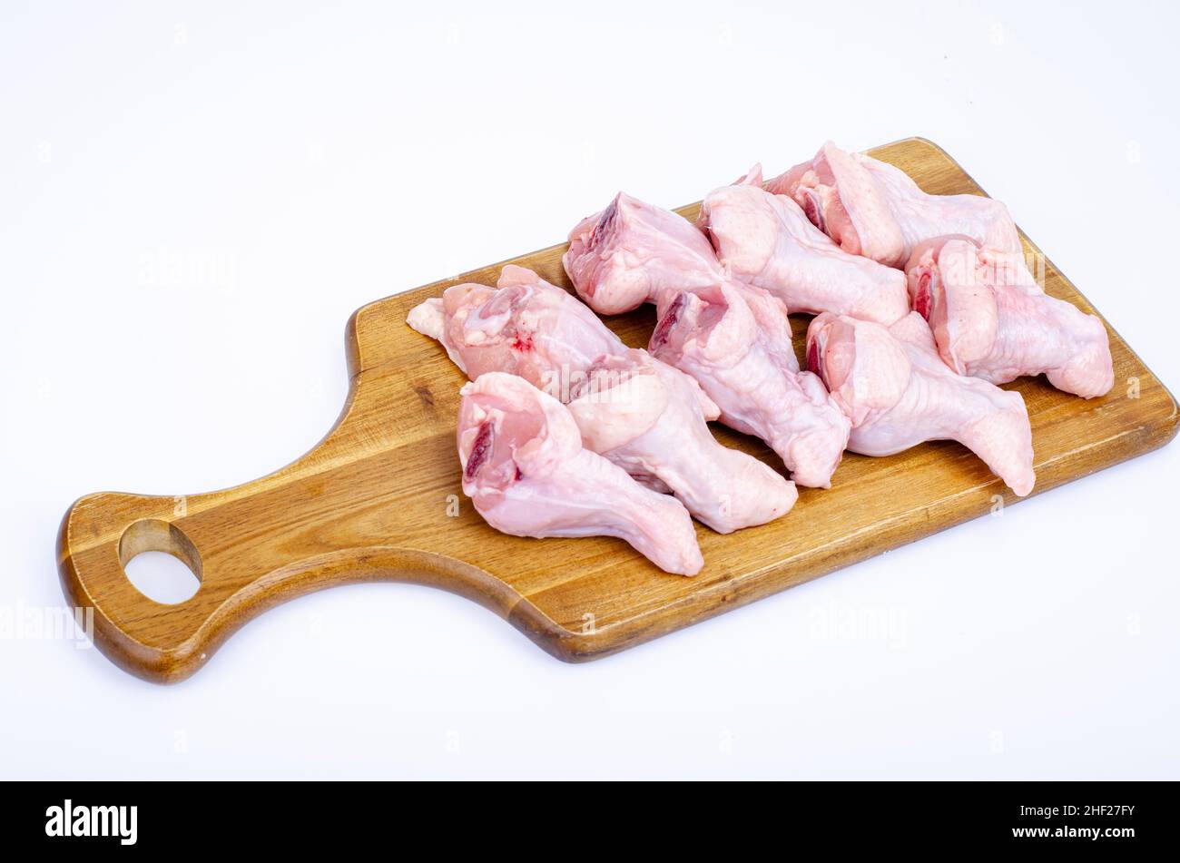 Raw chicken wings with bone and skin on wooden cutting board. Photo ...