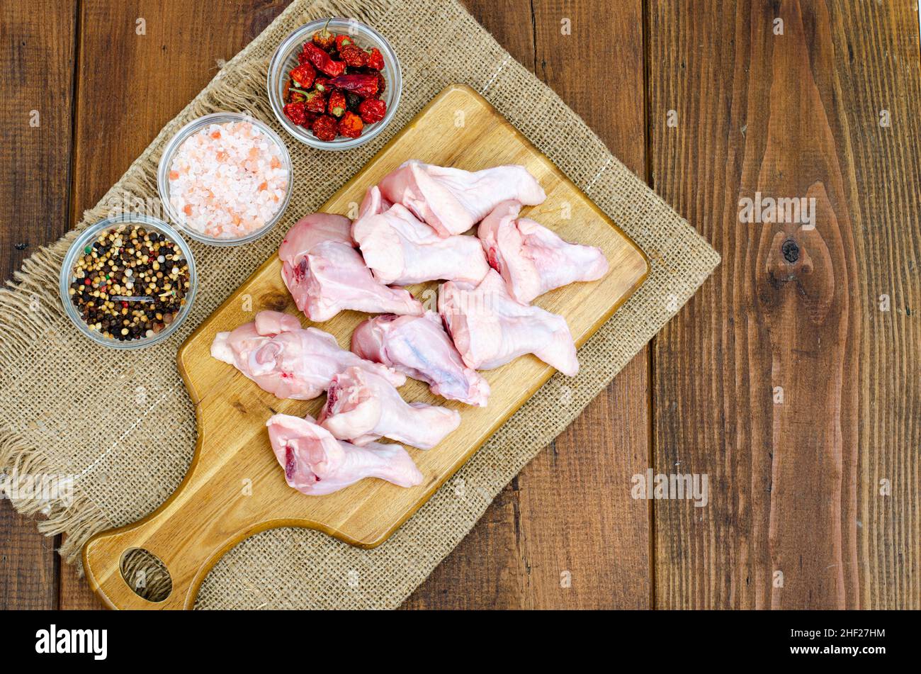 Raw chicken wings with bone and skin on wooden cutting board. Photo ...