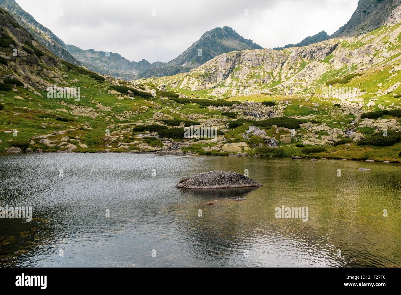 Beautiful lake in High Tatra mountains with stones in the middle and ...