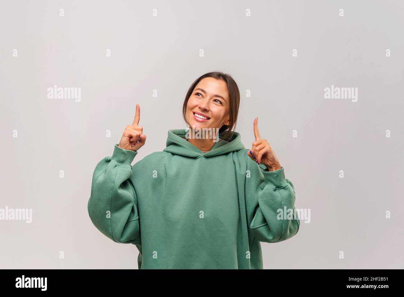 Wow, look above at advertisement. Portrait of pleasantly girl pointing ...