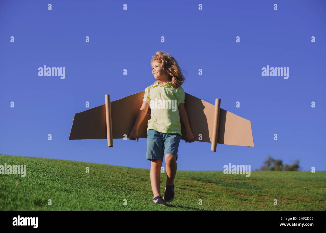 Kids fly. Funny child boy pilot flying with toy cardboard airplane ...