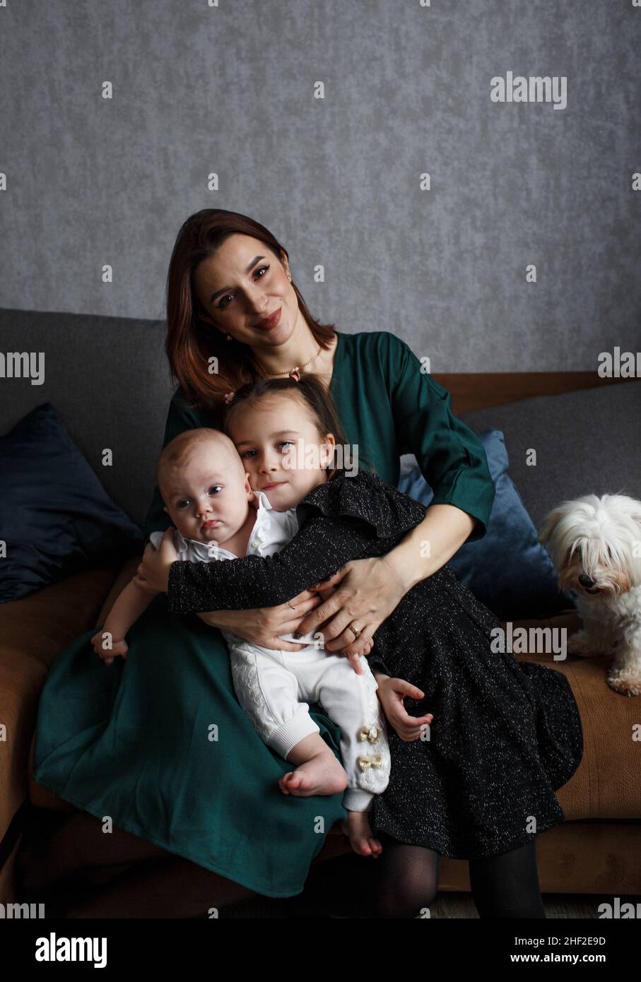 Happy family, young mother to relax, cuddle cute little kids, sit on ...