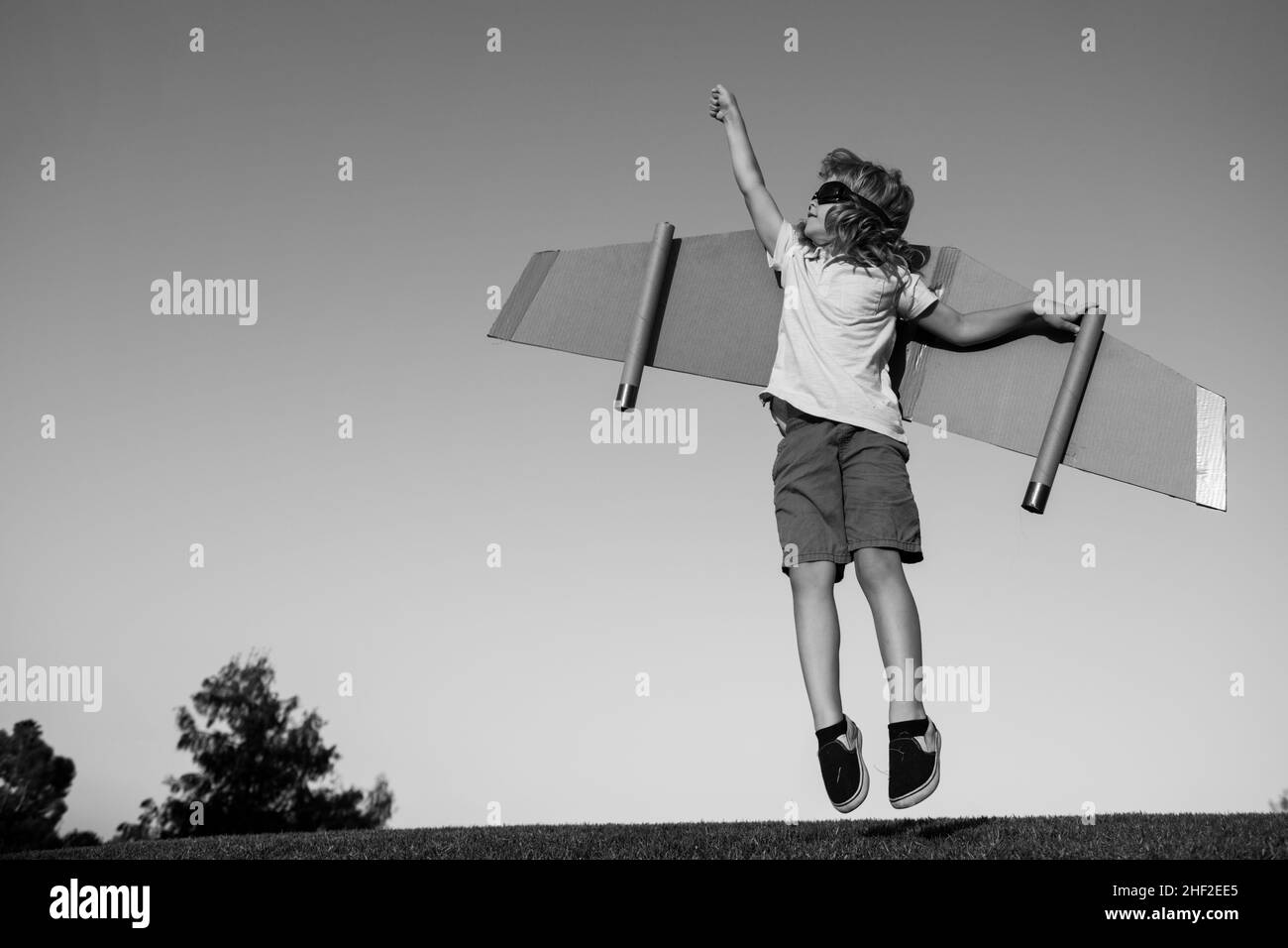 Kid superhero jump anf fly with jetpack. Child pilot play on summer day ...