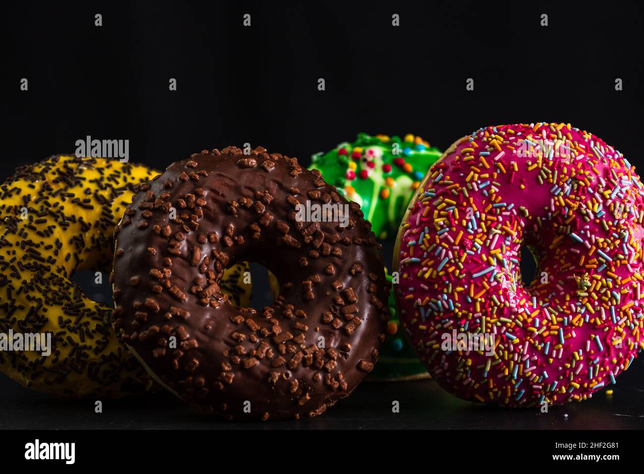Glazed donuts with sprinkles isolated. Close up of colorful donuts ...