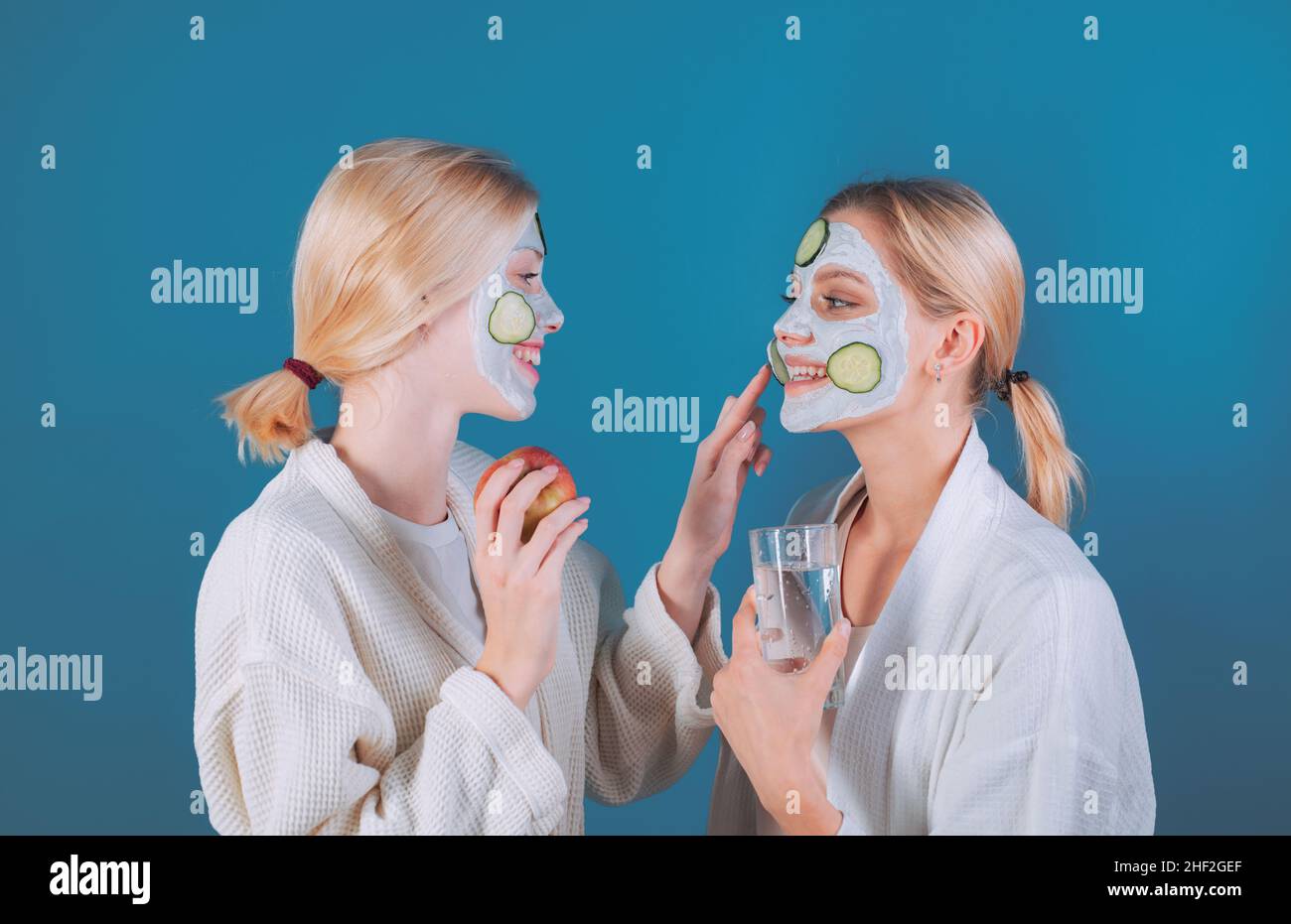Woman applying skin cream. Portrait Of two Beautiful Young Female ...