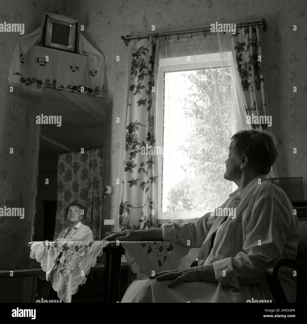 Woman in retro-styled interior looking to religious Jesus icon in ...