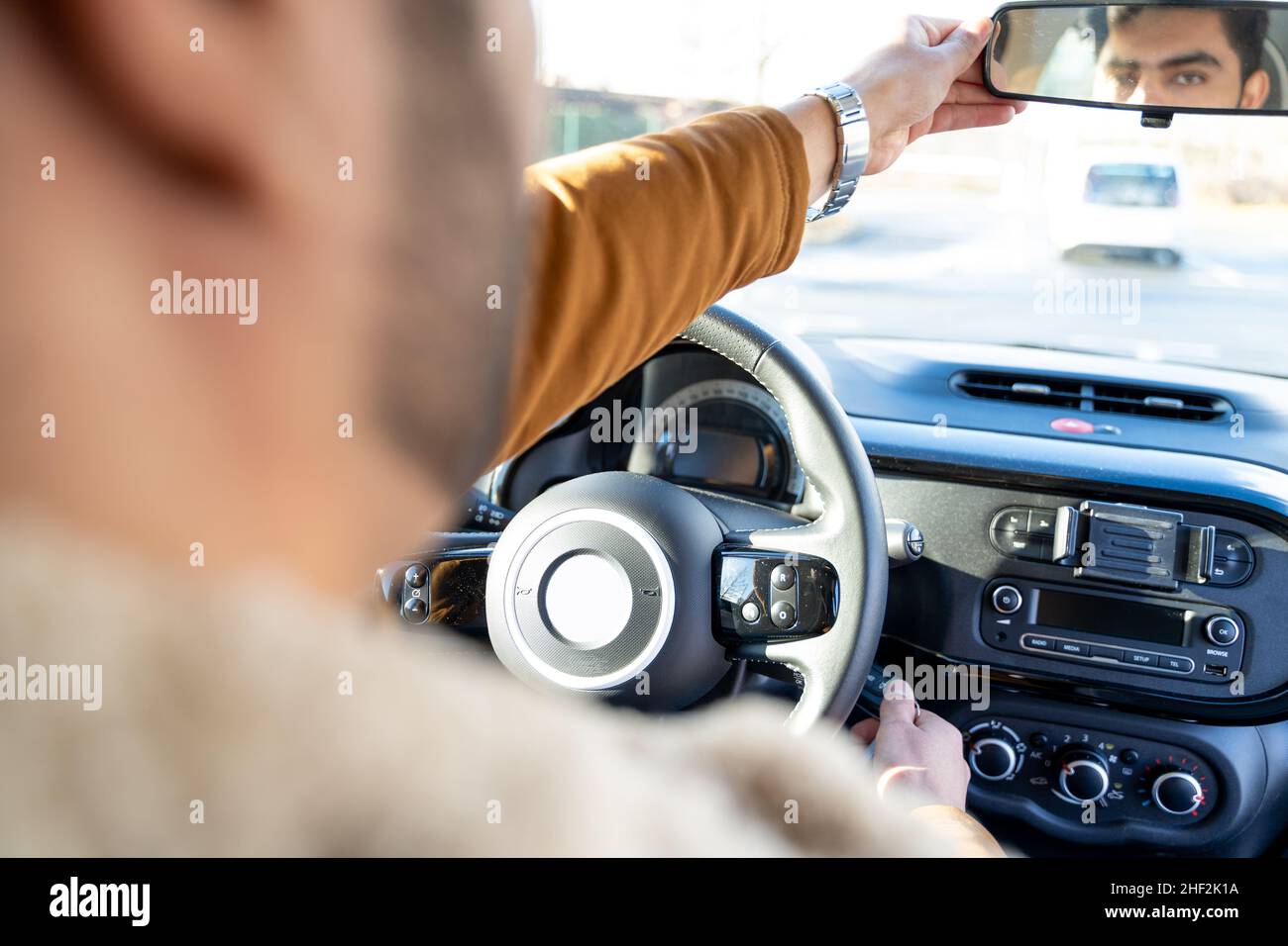 Man turning on engine with ignition key, align rearview mirror riding ...
