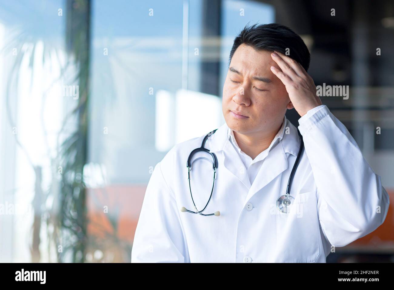 tired asian doctor, depressed man working in a modern clinic Stock ...