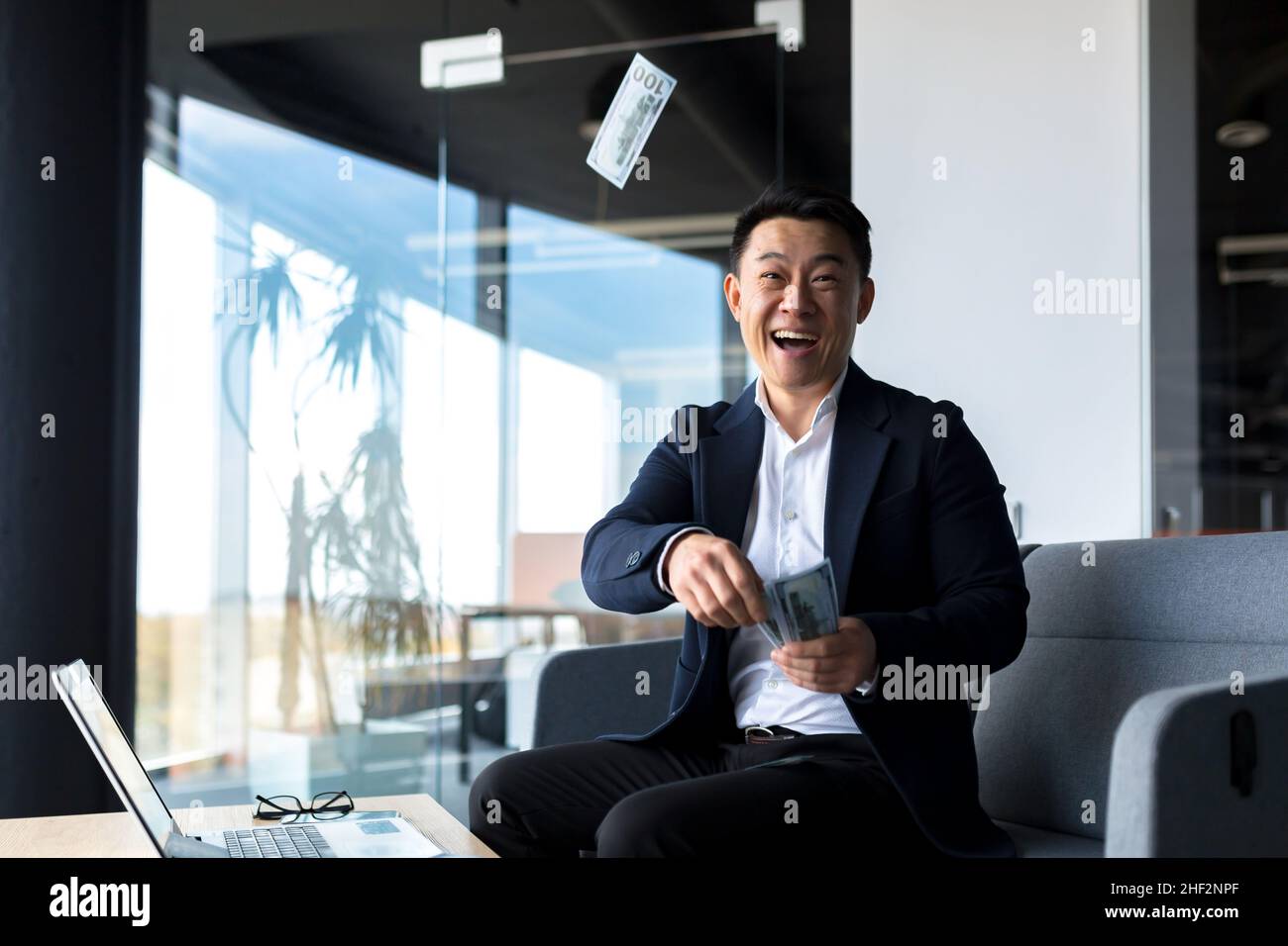 Happy and successful Asian, businessman working in office with laptop ...