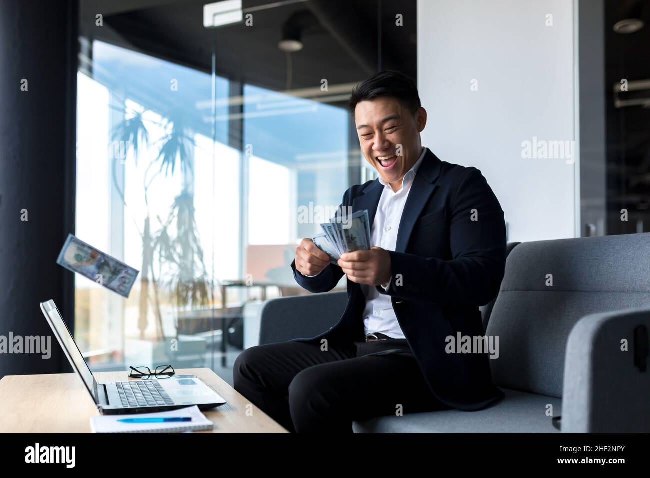 Happy and successful Asian, businessman working in office with laptop ...