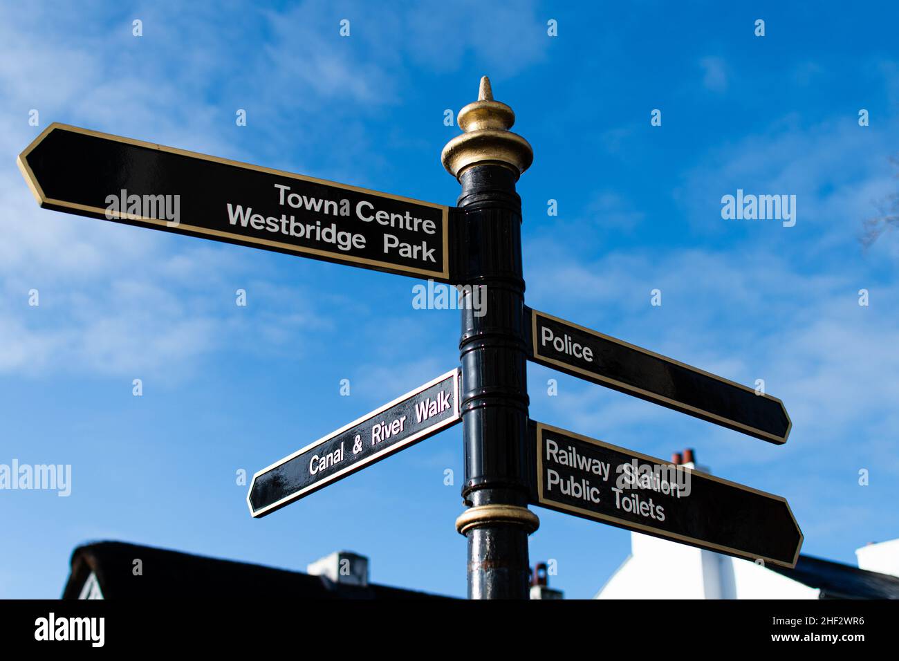Pedestrian sign post showing routes to town centre and police station ...