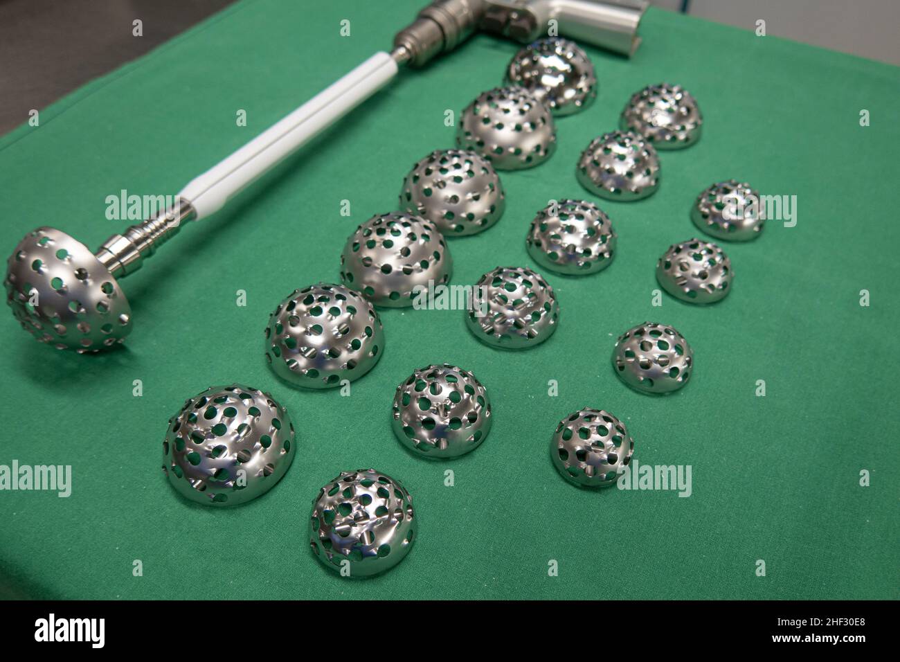 surgical cutters and an accumulator machine lie on a green surgical ...