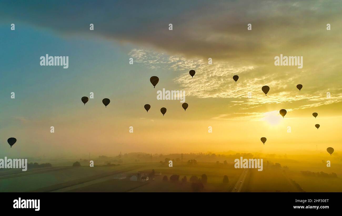 Aerial View of Many Hot Air Balloons Flying into the Sun and Mist On An ...