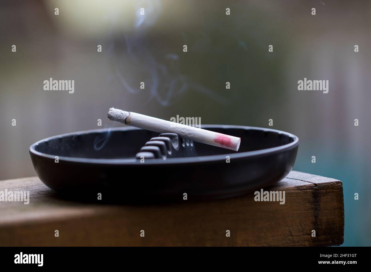 Tobacco cigarette in ashtray smoking concept. Cigarette with lipstick ...