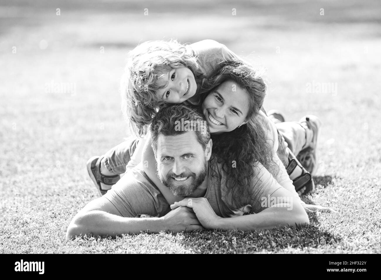 Family hugging and embracing on grass in park Stock Photo - Alamy