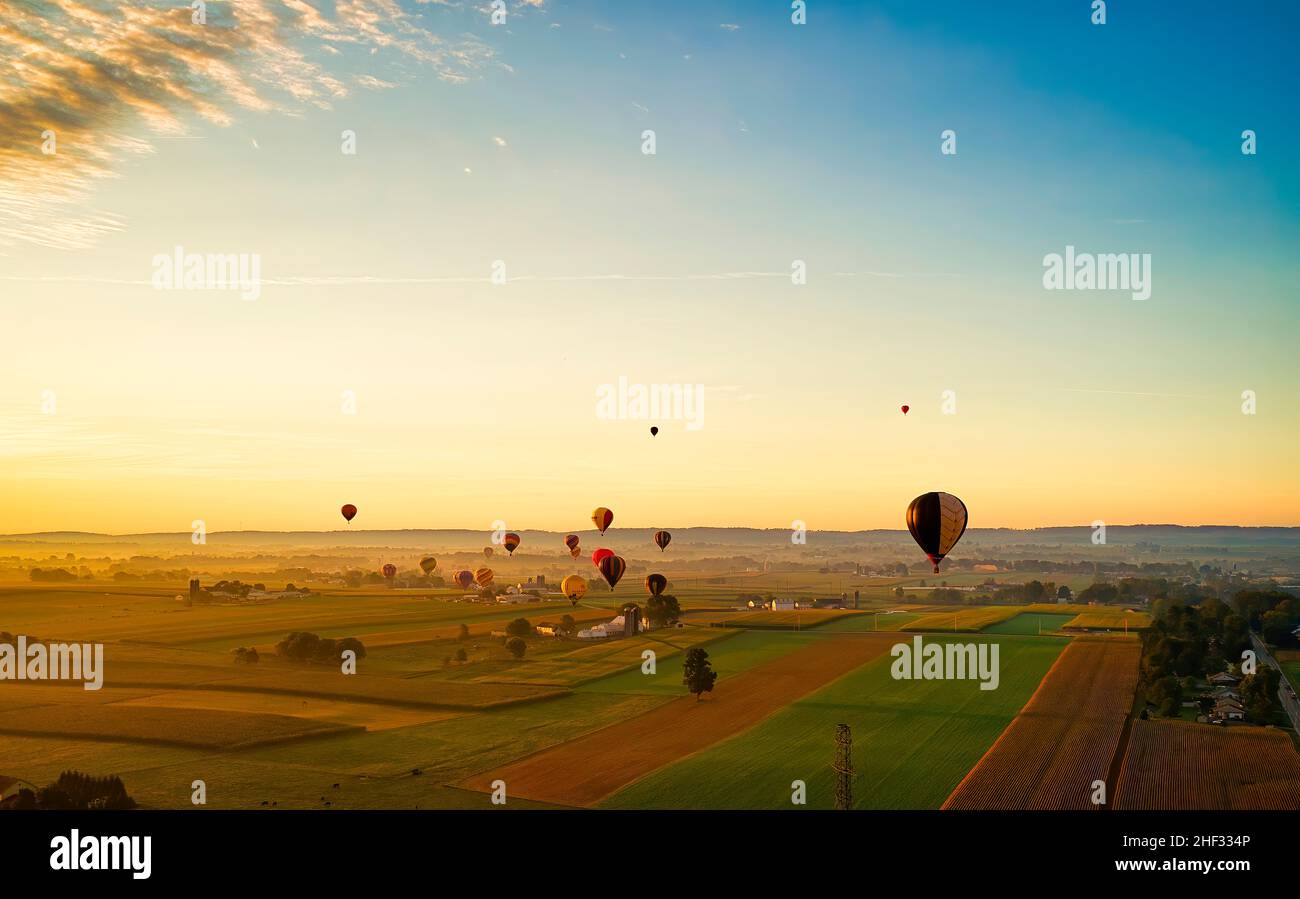 Aerial View of Many Hot Air Balloons In Flight Thru Rural Countryside ...