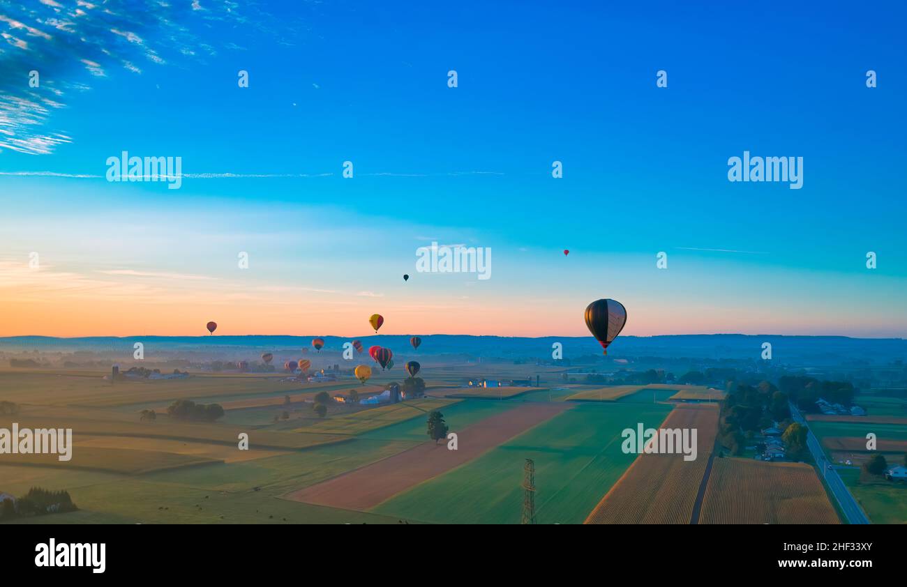 Aerial View of Many Hot Air Balloons In Flight Thru Rural Countryside ...