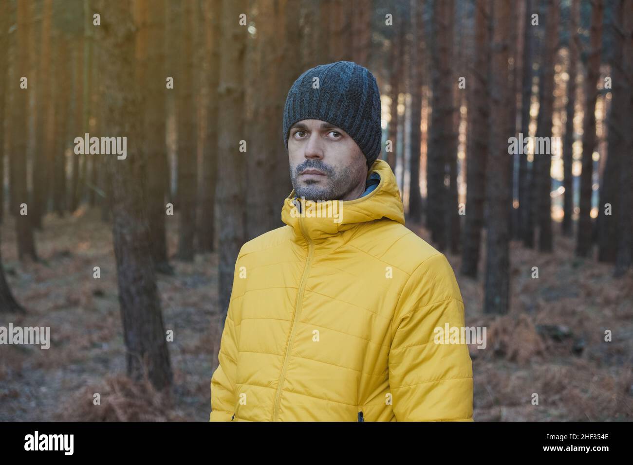Sad man in yellow coat in the forest Stock Photo - Alamy