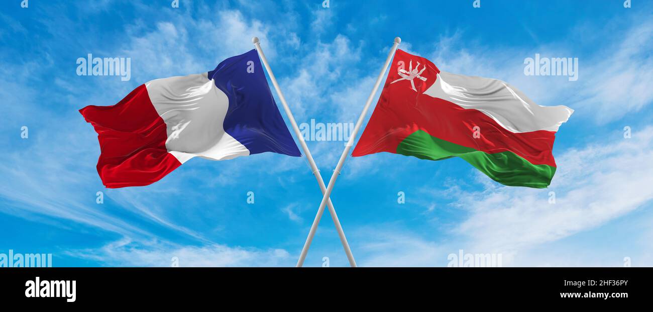 crossed national flags of France and Oman flag waving in the wind at ... crossed national flags of France and Oman flag waving in the wind at ...