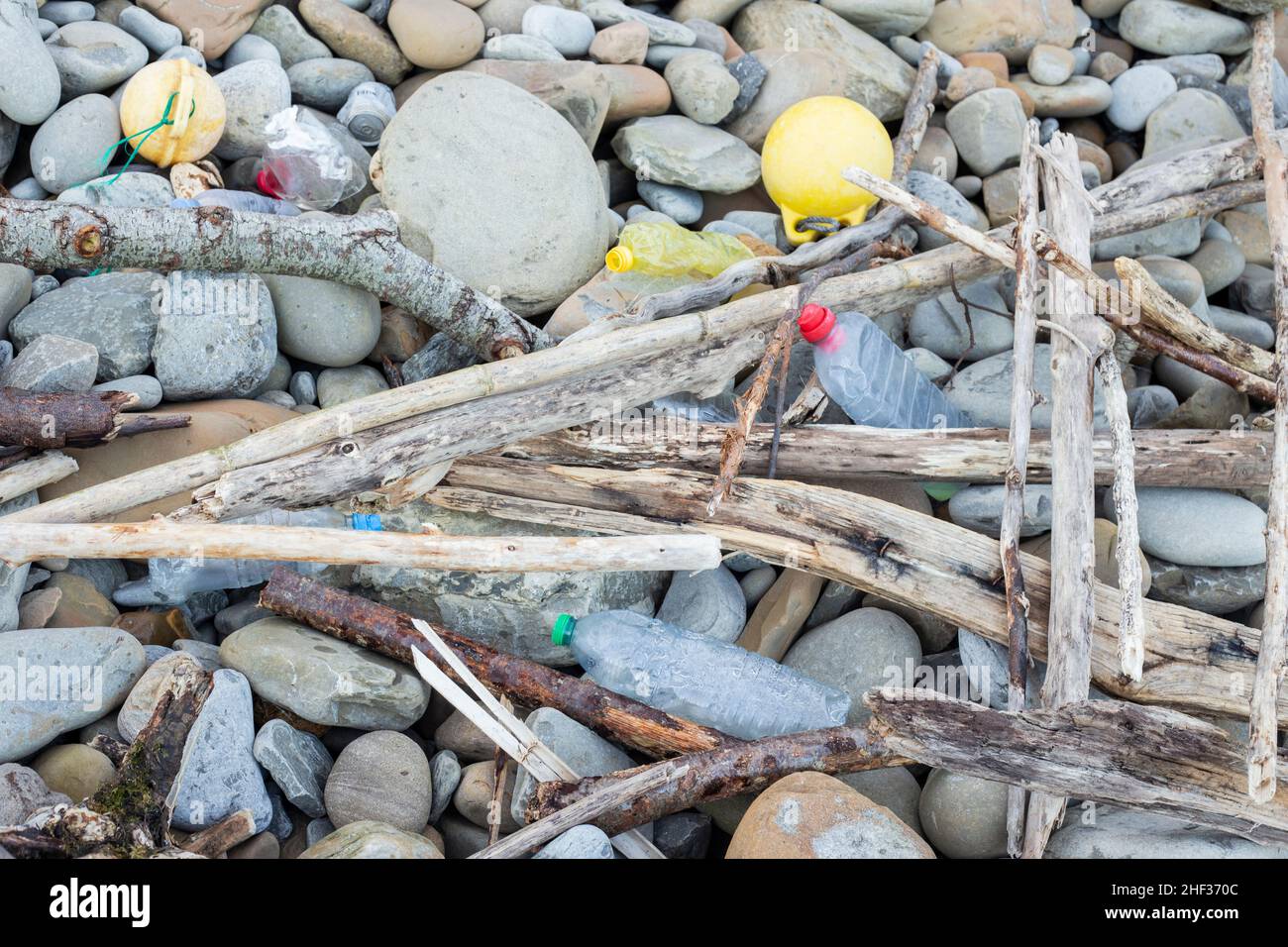 A rubbish among the rocks of the sea, plastic bottles, cans and ...