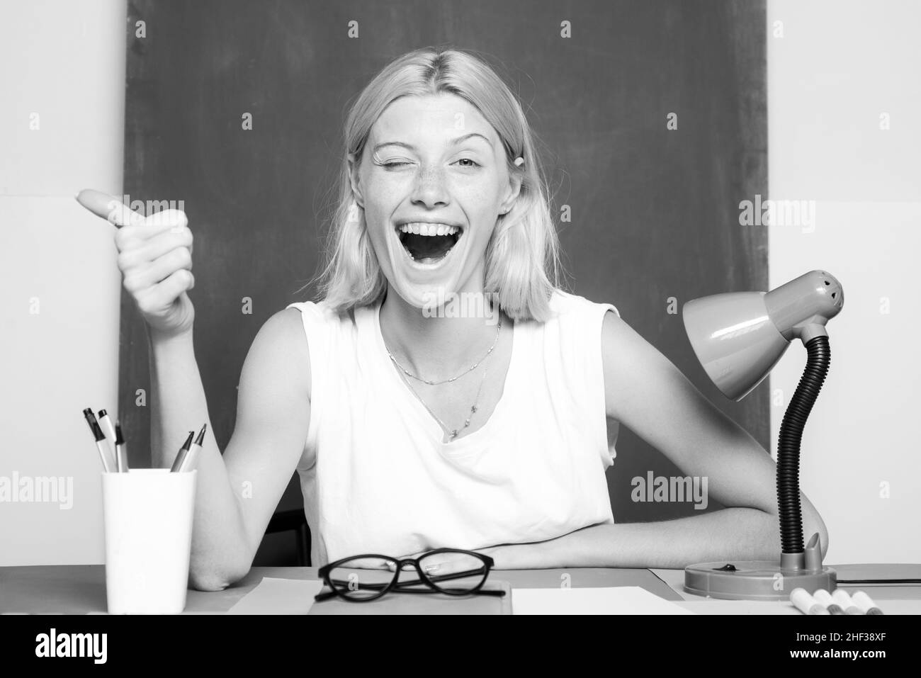 Learn with fun. Funny female teacher sitting at her workplace and ...