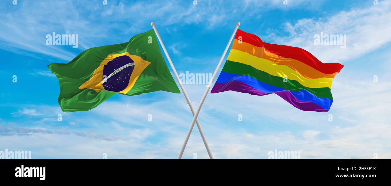 crossed national flags of Brazil and LGBT Pride flag waving in the wind ...
