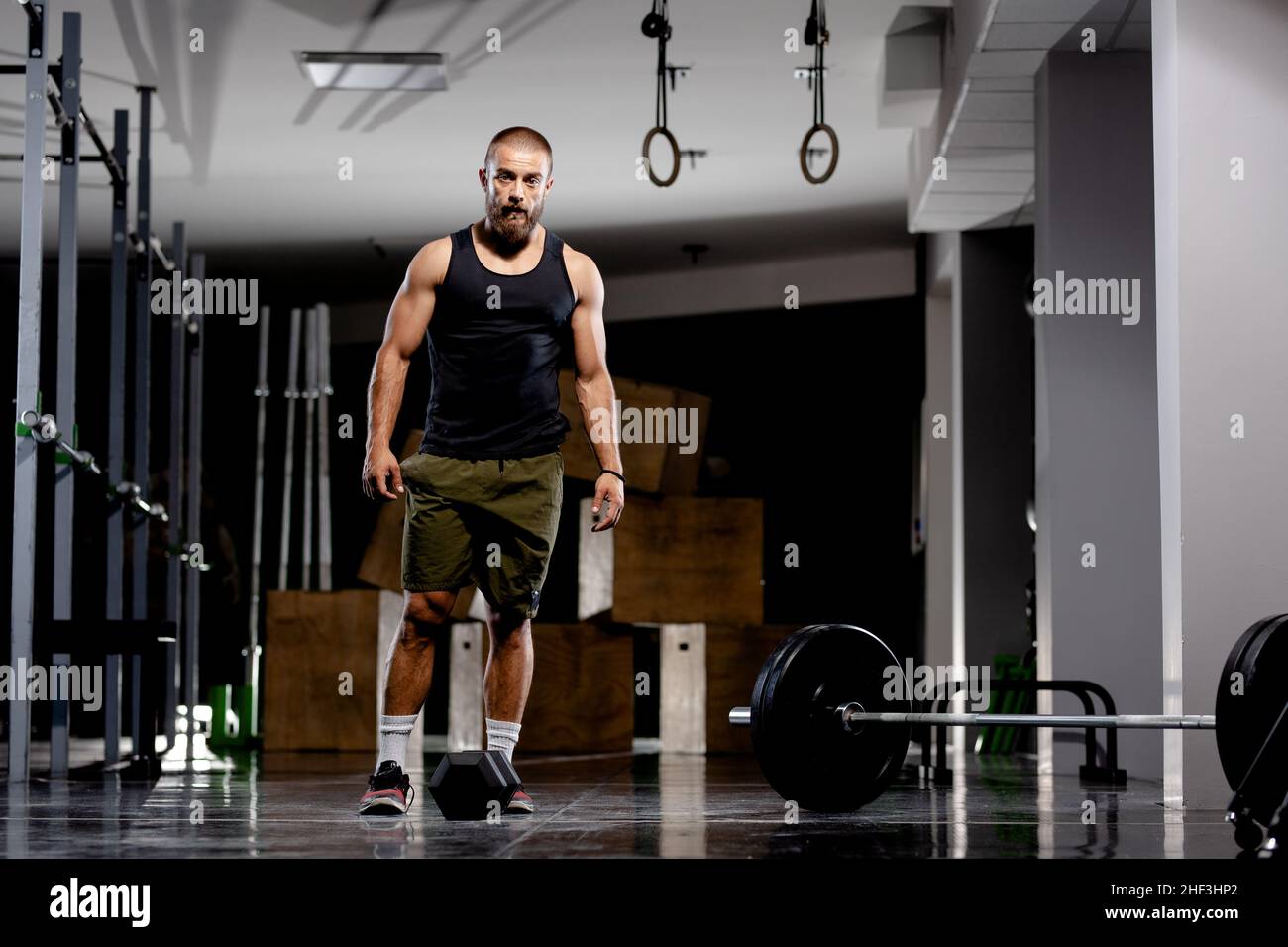 Muscular athlete lifting weights. Standing next to heavy barbell Stock ...
