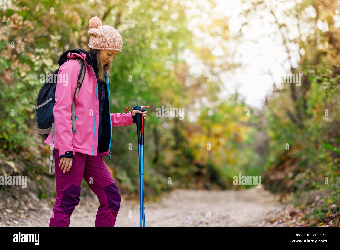 Hiker girl standing on a wide trail in the mountains. Backpacker with ...