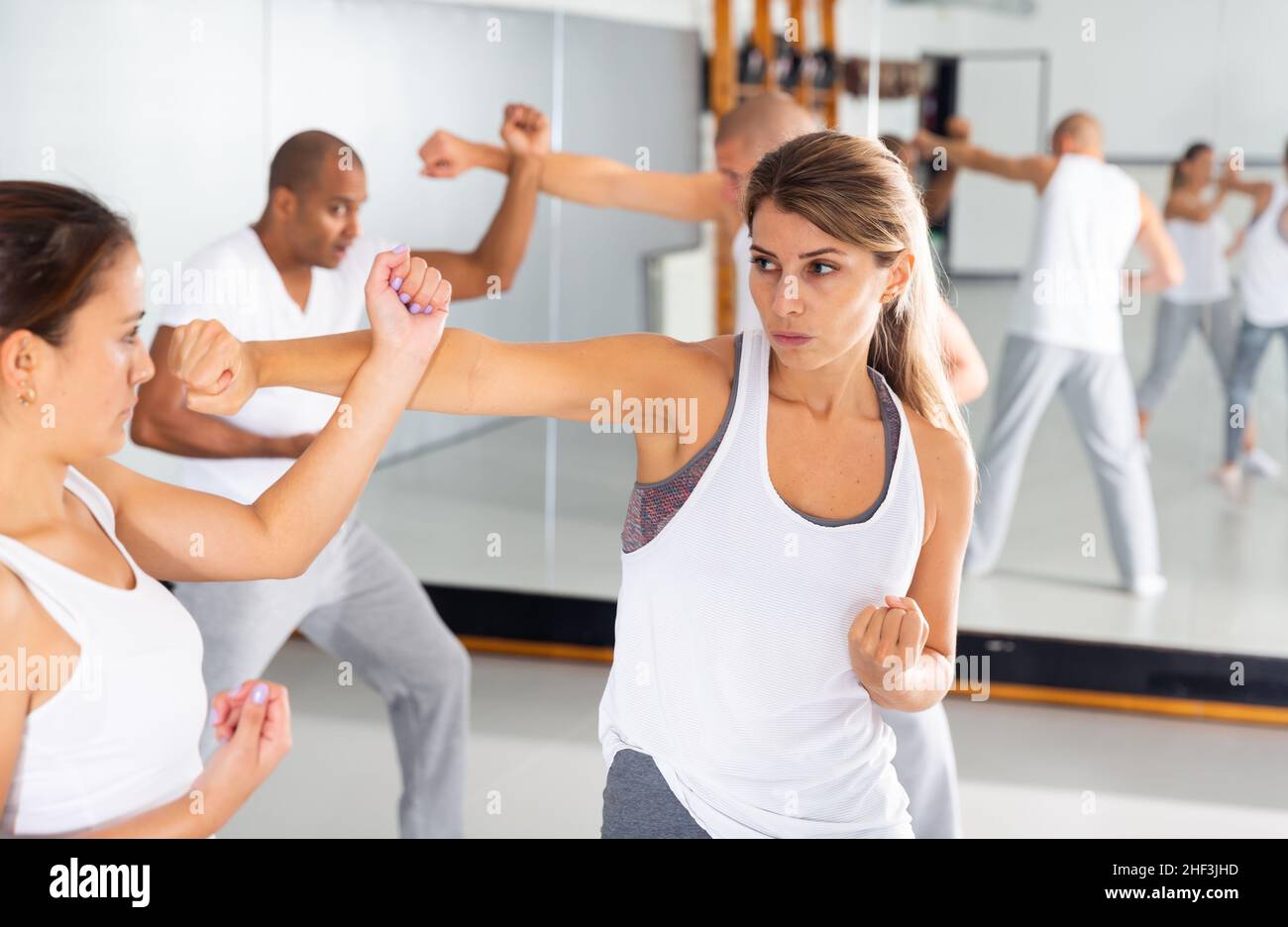 Young woman practicing self defence techniques with female partner ...