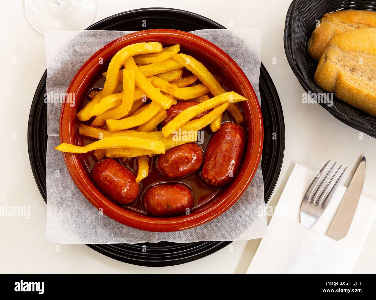 Chorizo with cider served with French fries Stock Photo - Alamy