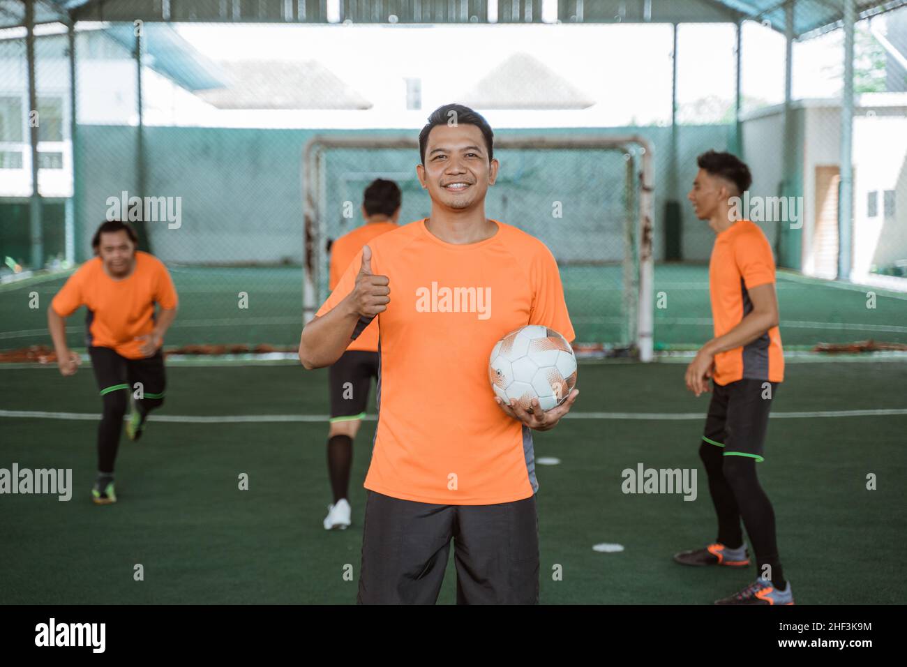 Male futsal player standing pose with thumbs up Stock Photo - Alamy