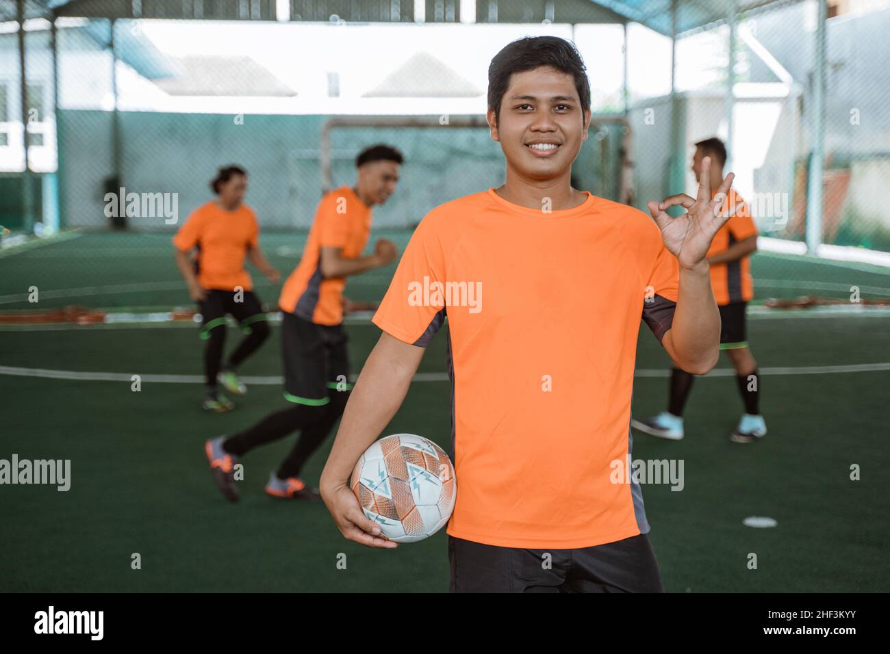 Asian male futsal player smiling with ok hand gesture Stock Photo - Alamy
