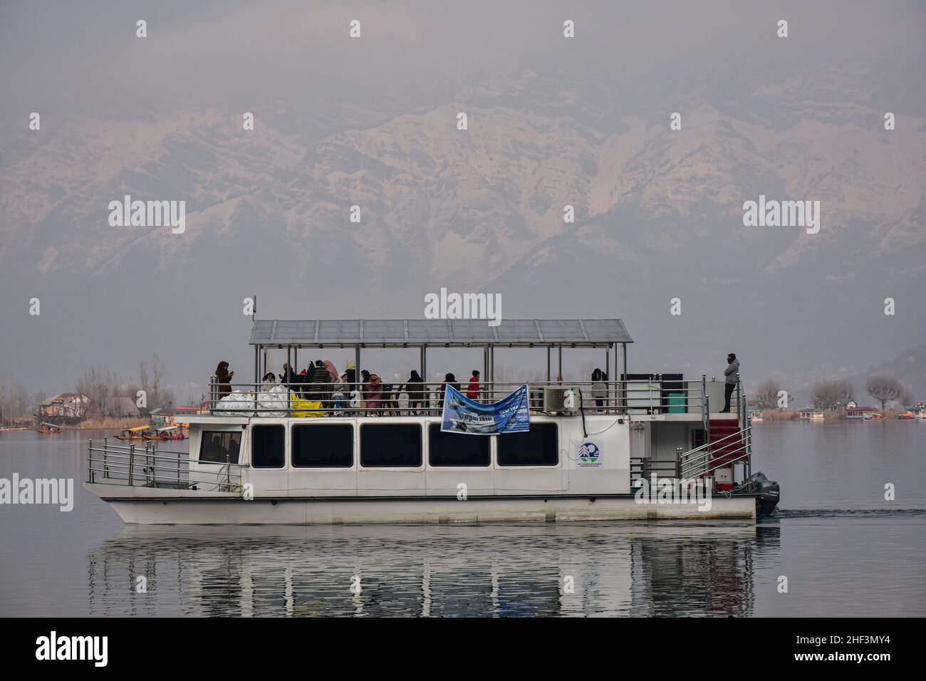 Tourists seen enjoying on the passenger ferry during a cold winter day ...