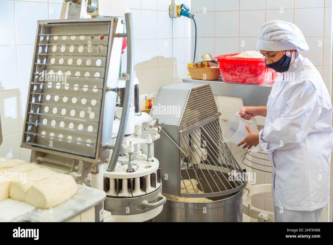 Female bakery worker controlling dough kneading Stock Photo - Alamy