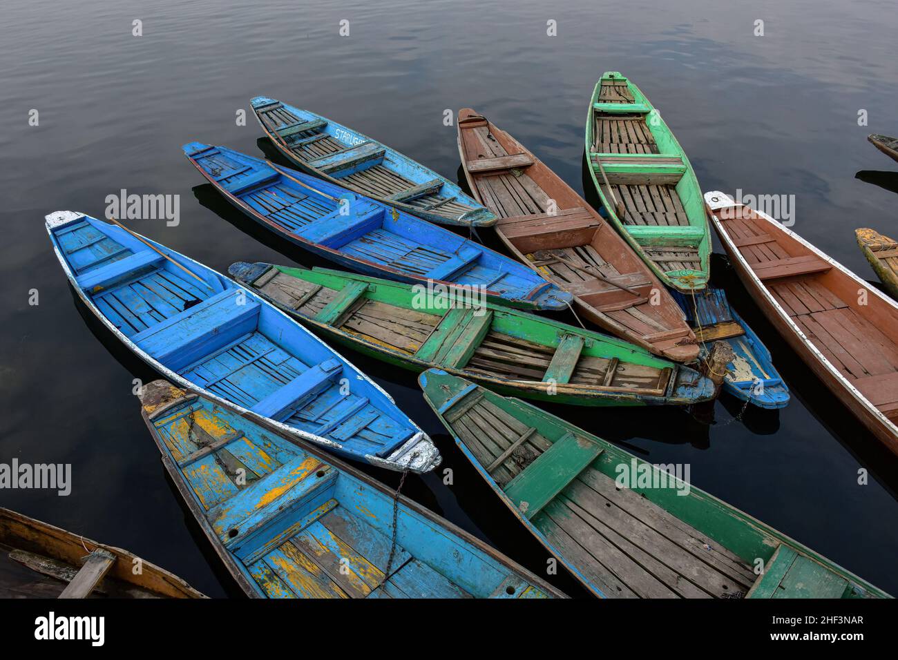 Boats are seen moored to the bank of Dal Lake during a cold winter day ...