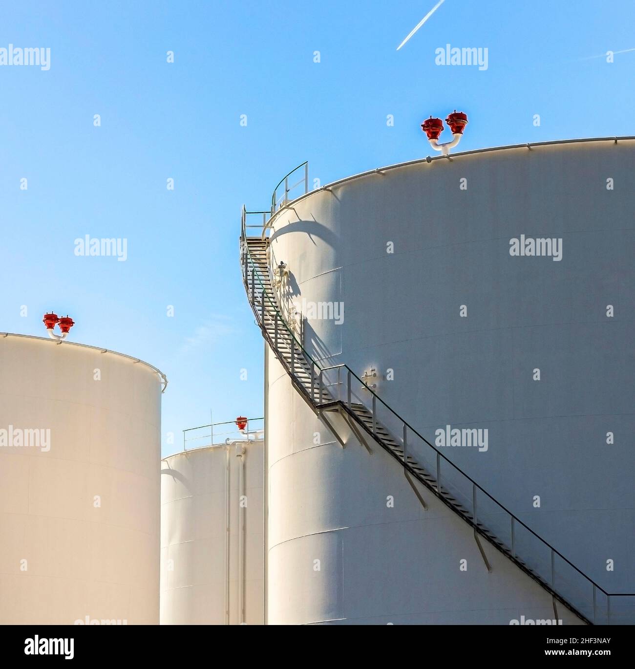 white tanks in tank farm with iron staircase under blue sky Stock Photo ...