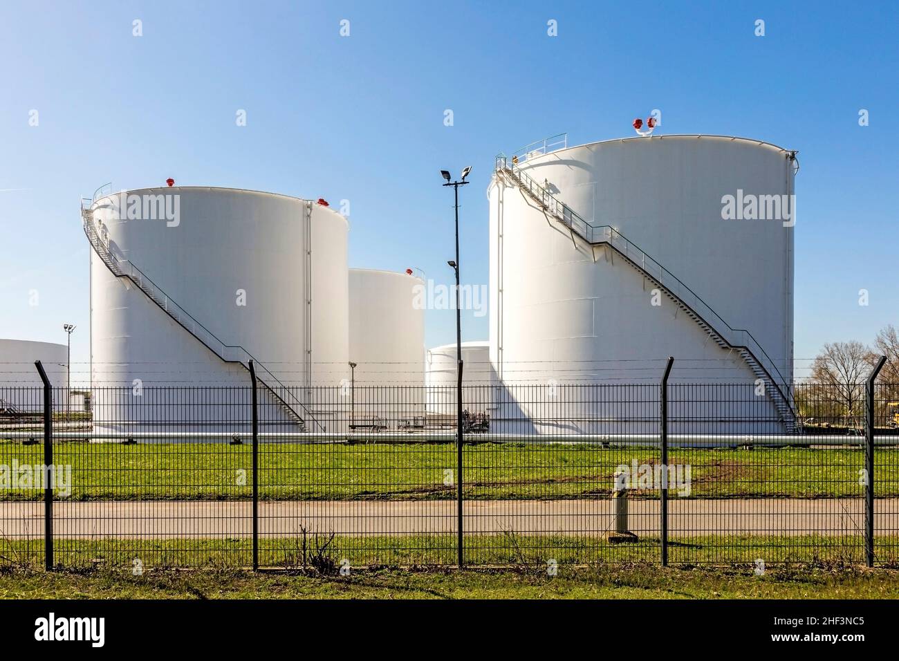 white tanks in tank farm with iron staircase under blue sky Stock Photo ...