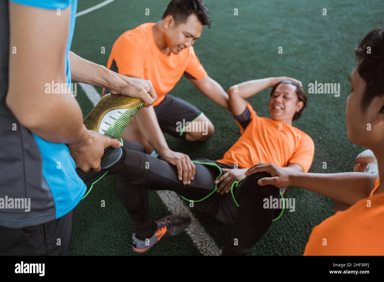 a group of male futsal players helping a friend Stock Photo - Alamy