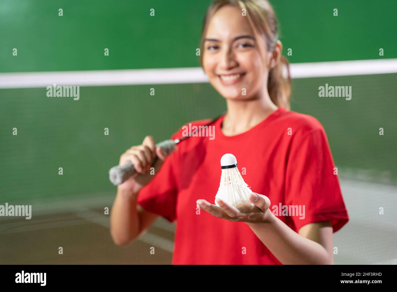 Beautiful female badminton player holding shuttlecock while standing on ...