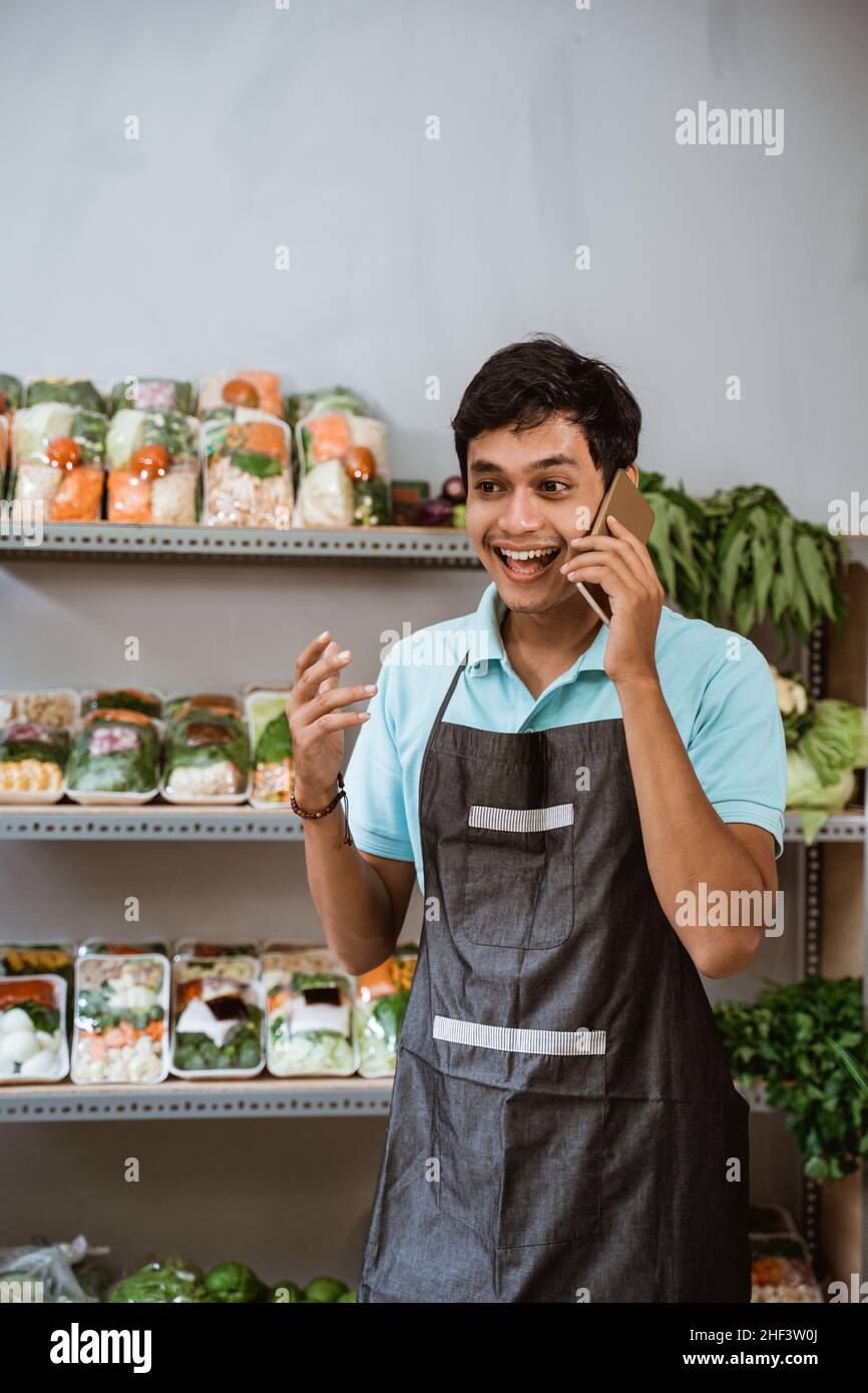 Happy sales man making a call using a smartphone Stock Photo - Alamy