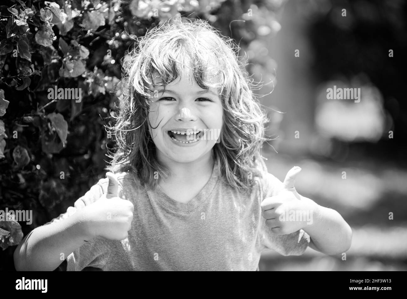 Portrait of a happy laughing child. Close up positive kids face, thumbs ...