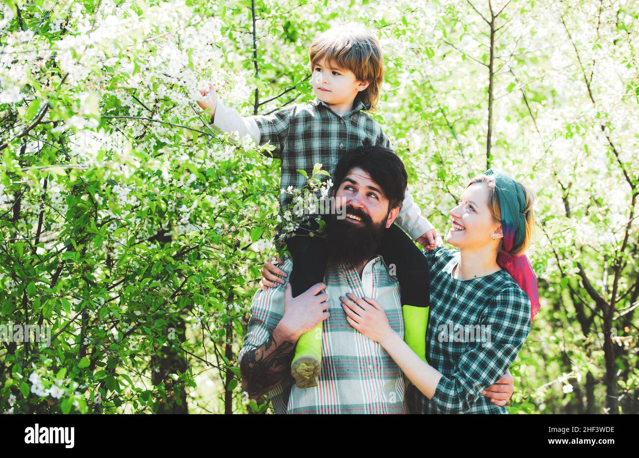 Portrait of a young happy family in yard during spring season. Life for ...