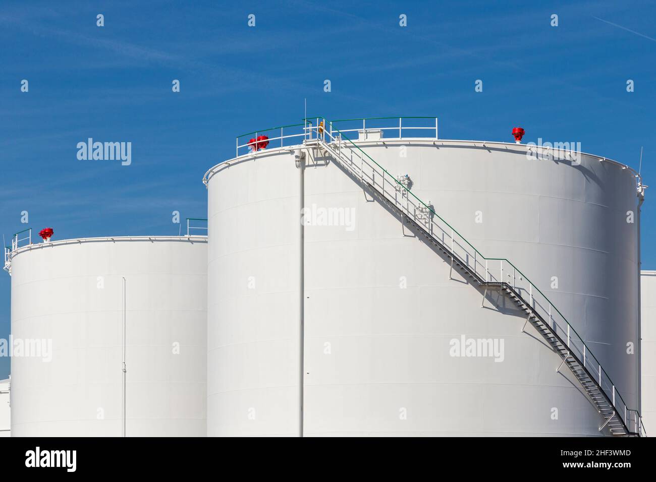 white tanks in tank farm with iron staircase under blue sky Stock Photo ...