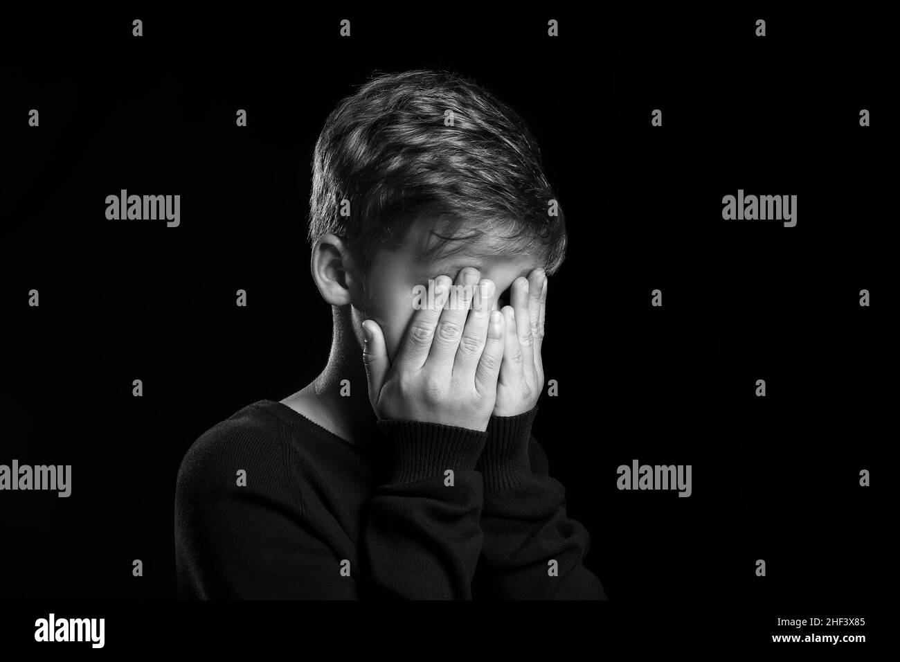 Crying little boy on black background Stock Photo - Alamy