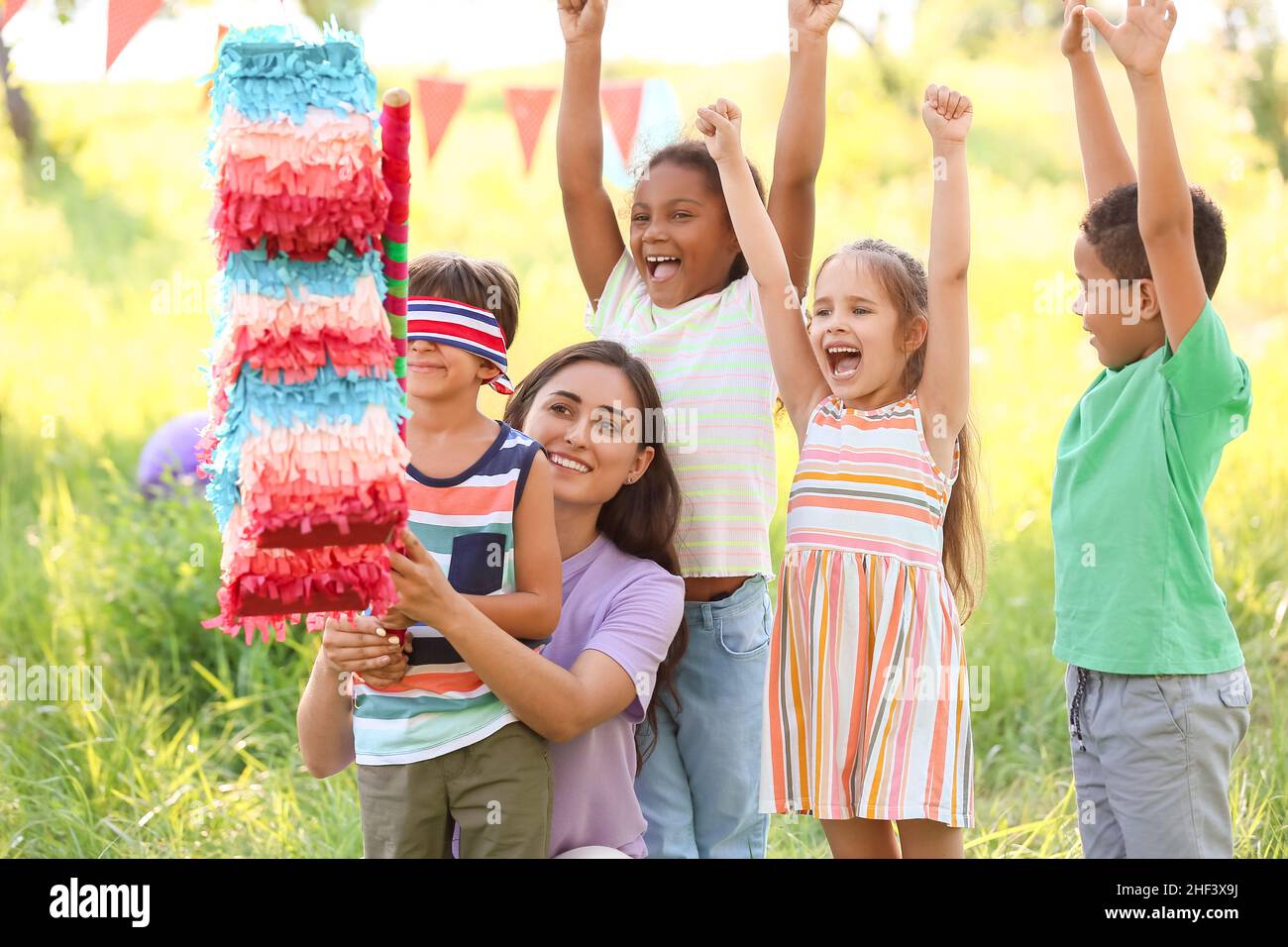 Woman and cute children at pinata birthday party Stock Photo - Alamy