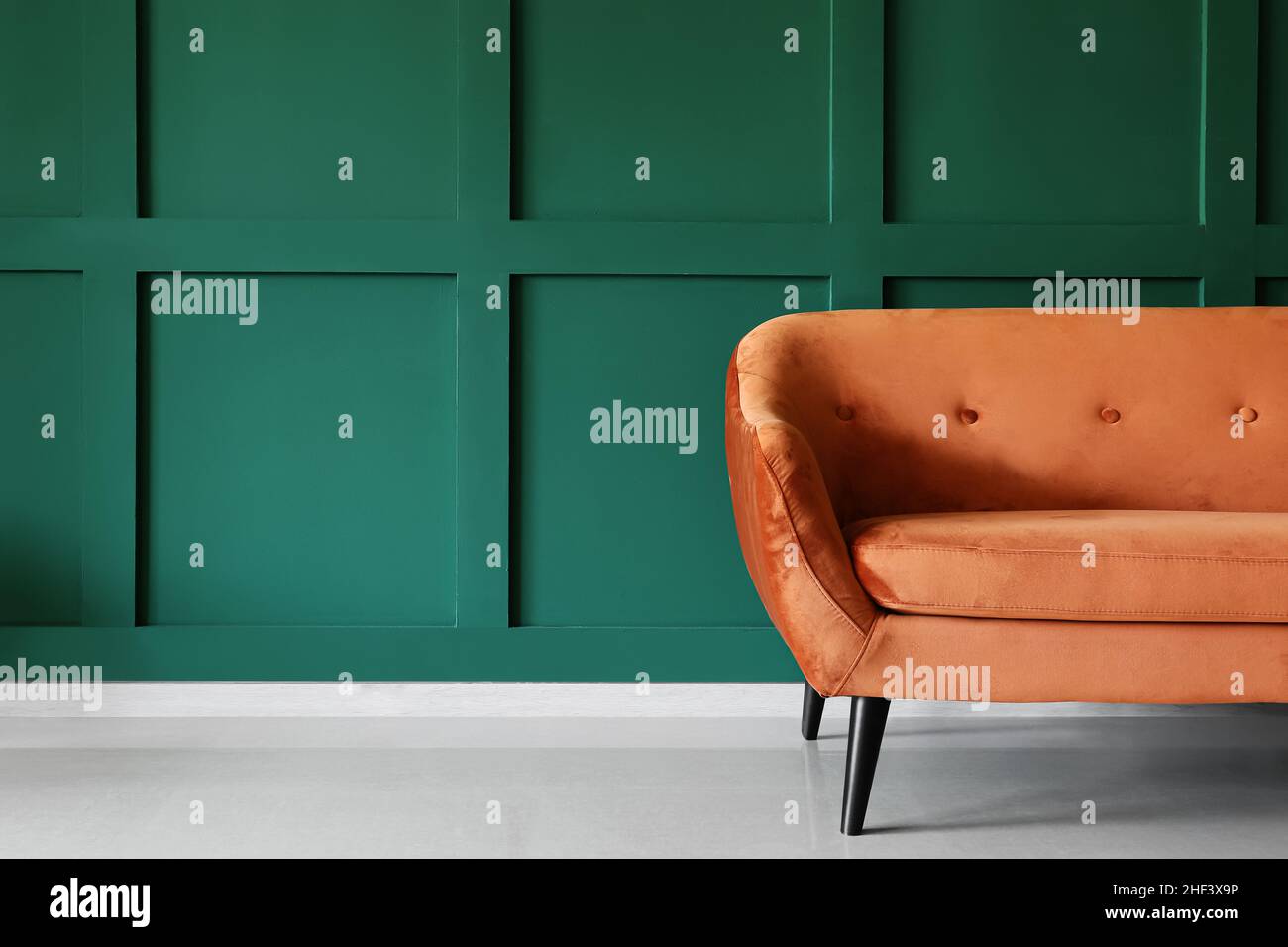 Comfy red couch near green wall Stock Photo - Alamy